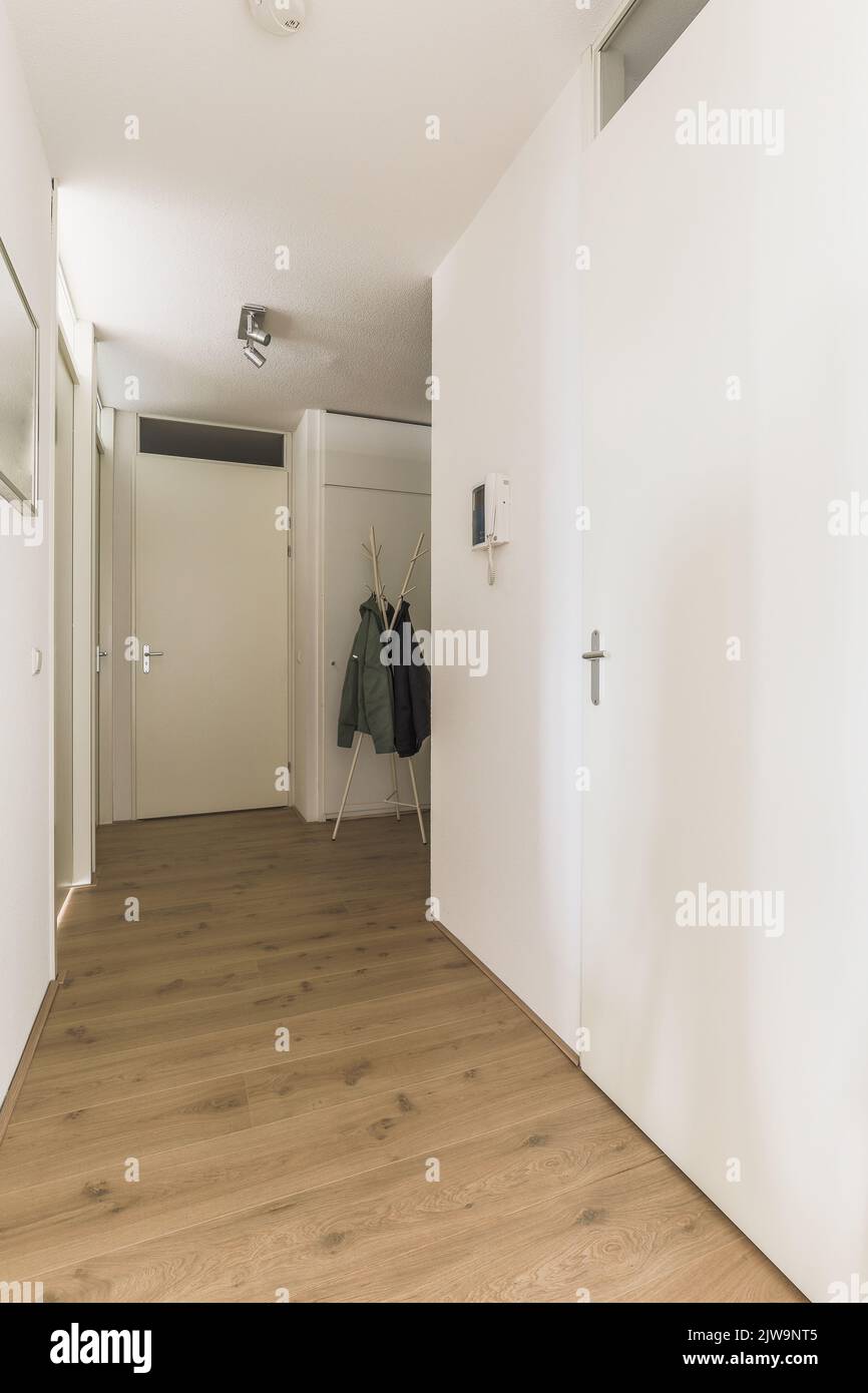 Light narrow hallway with many doors in white walls Stock Photo - Alamy