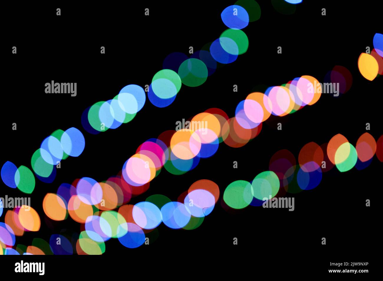 Three multicolored garlands, defocused bokeh lights on an isolated ...