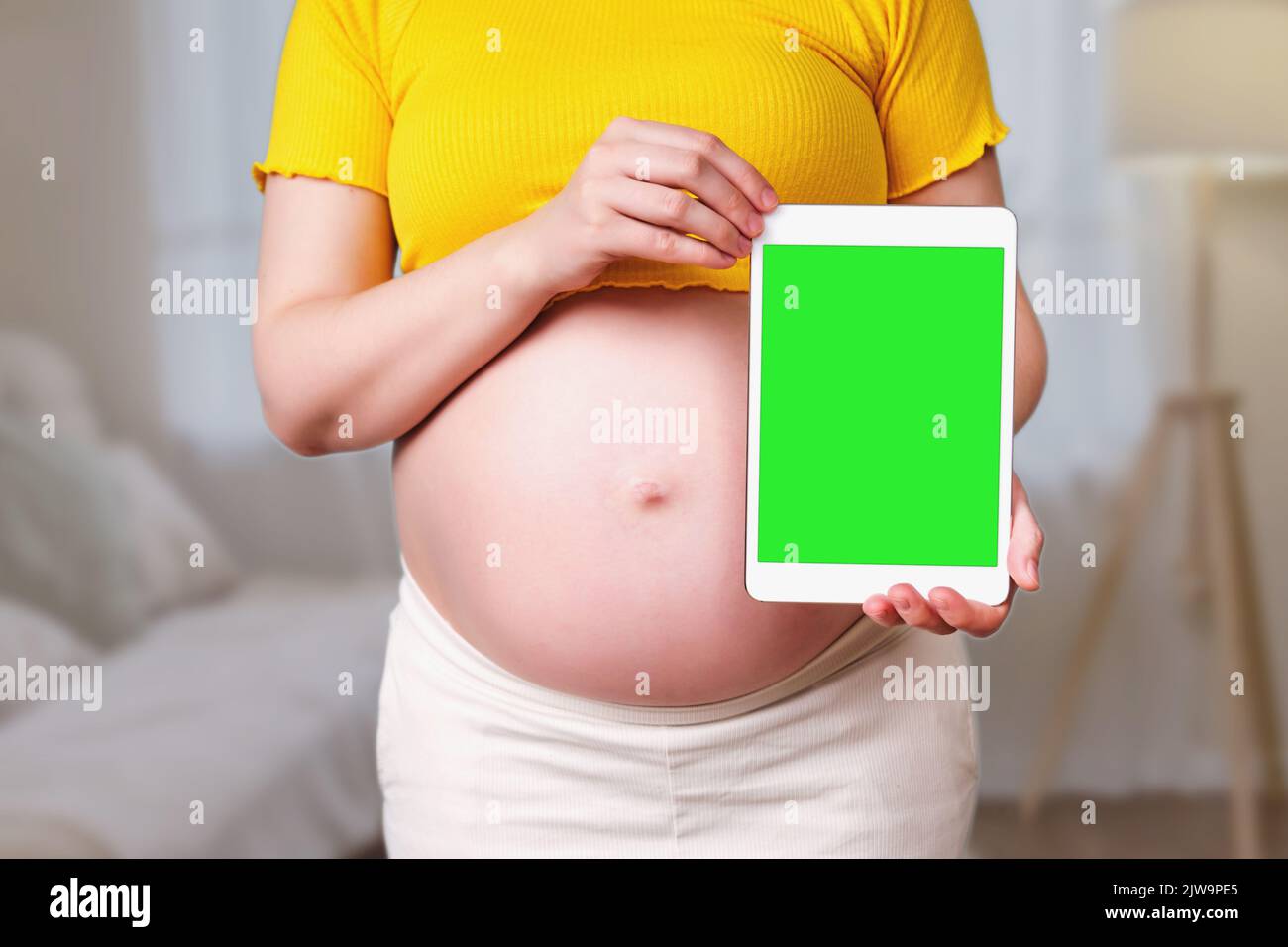 Pregnant woman and digital tablet screen, mockup copy space Stock Photo ...
