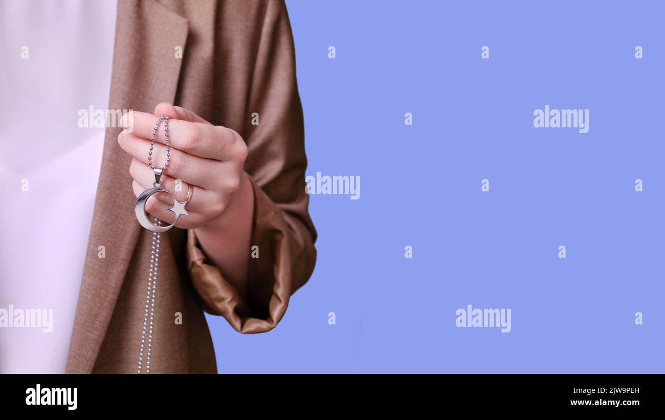 Woman teacher holding muslim crescent moon religious symbol on studio ...