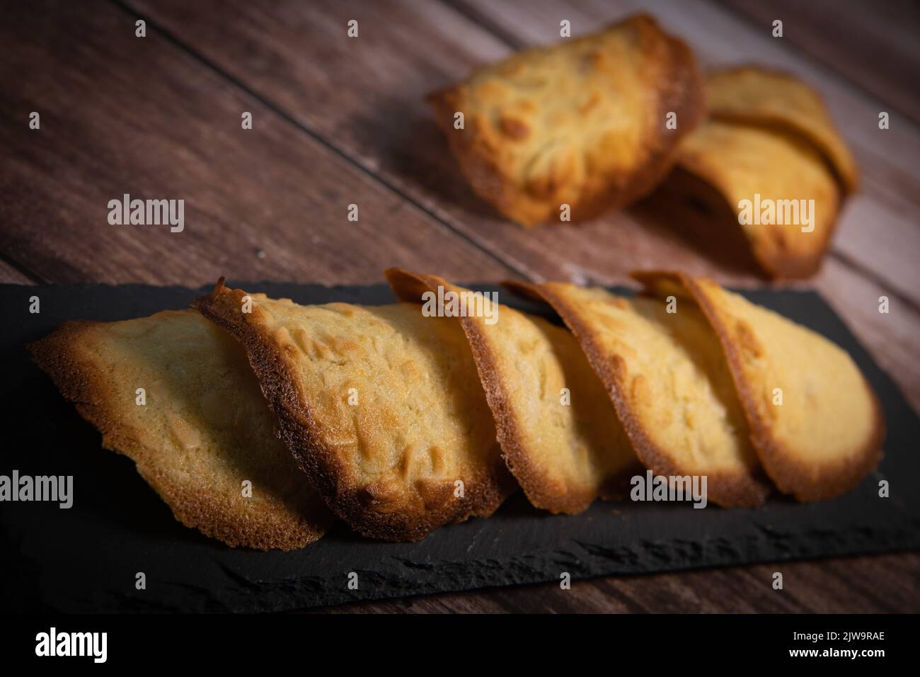 French delicacy pastry tuile with almond on wood background Stock Photo ...