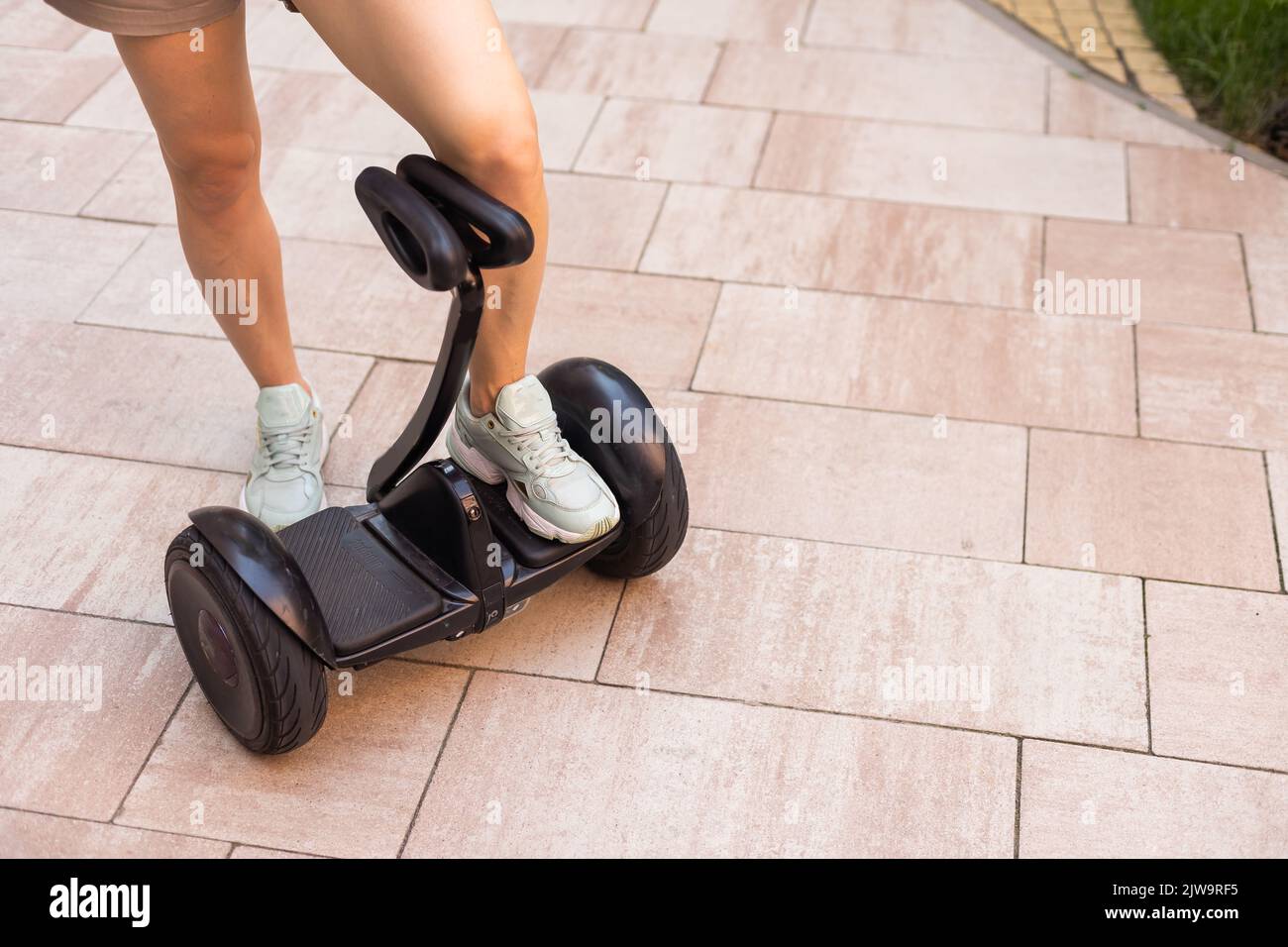woman riding electric mini segway hover board scooter in green park ...