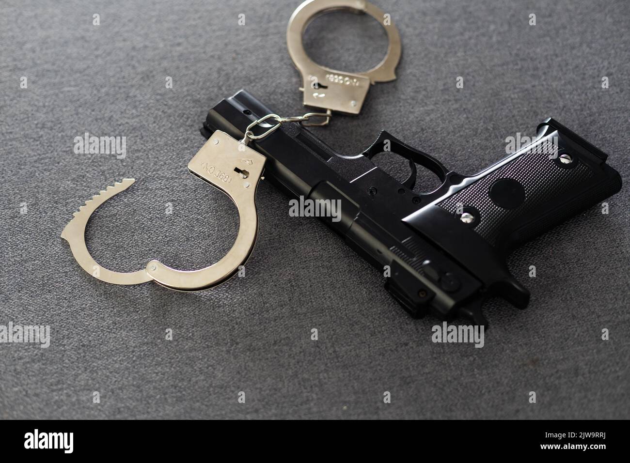 Pistol and handcuffs on black textured table. Ammunition of law ...