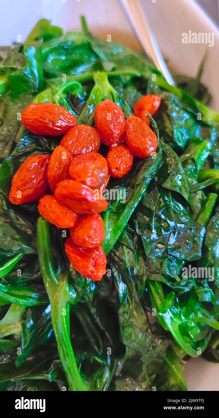 Steamed Chinese vegetable of pea shoots with red goji berry Stock Photo ...
