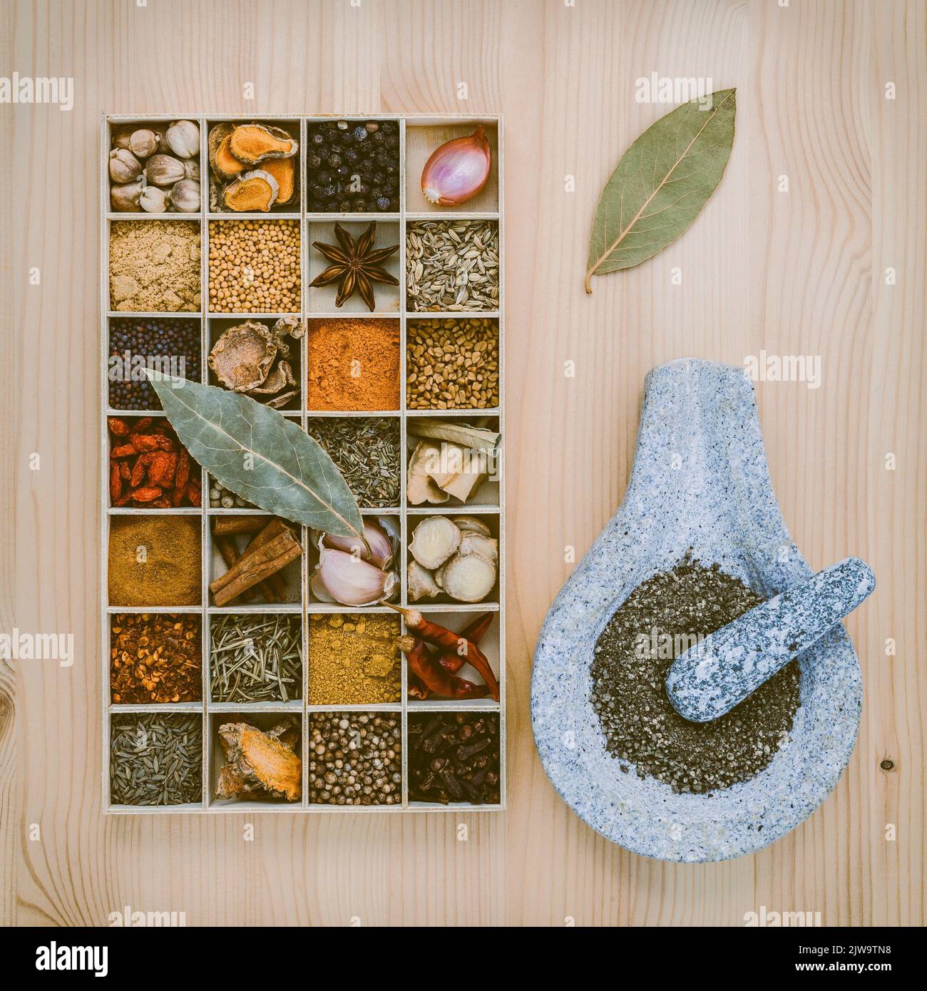 A top view of a collection of different kinds of spices and condiments ...