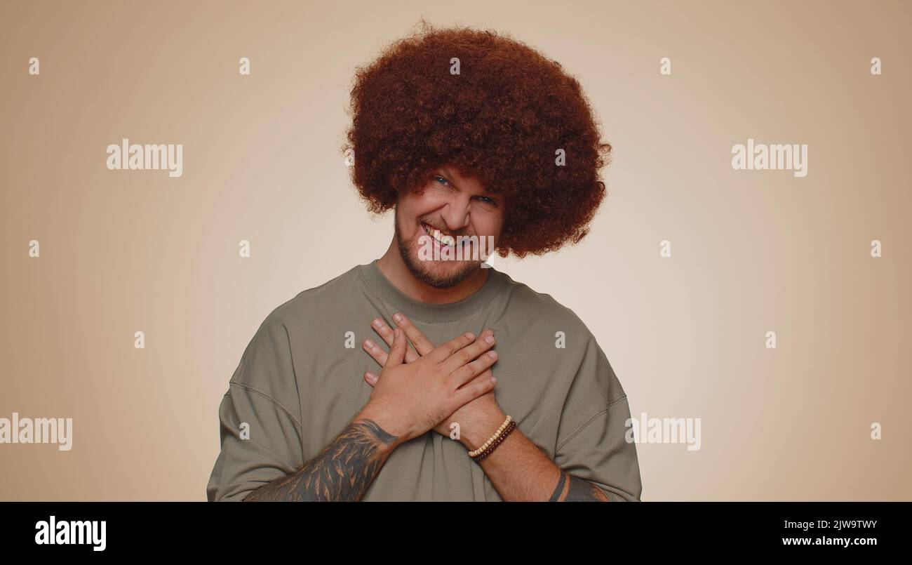 Joyful man with lush hairstyle laughing out loud after hearing ...