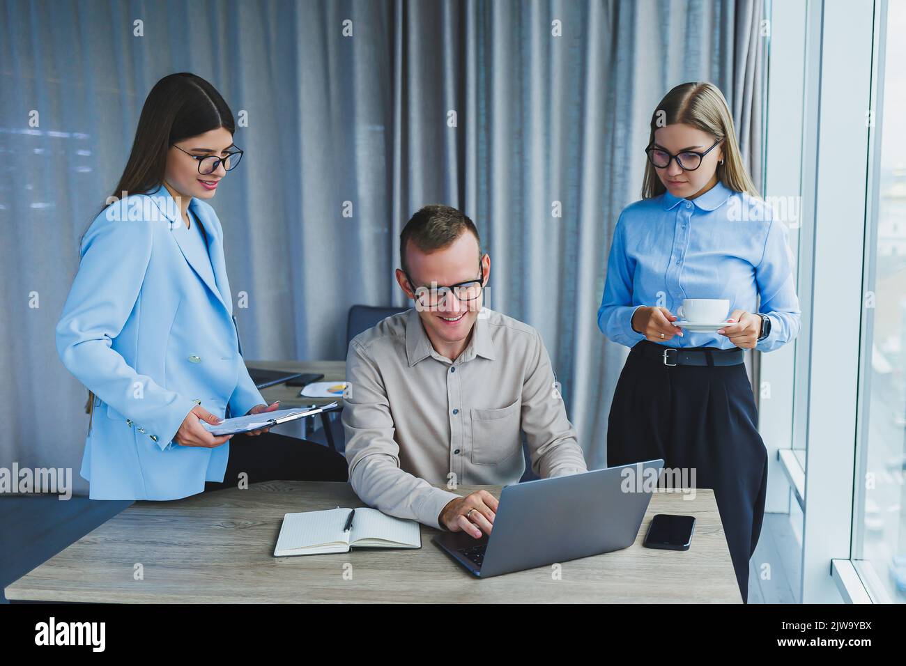 Successful young business people laughing while collaborating on a new ...