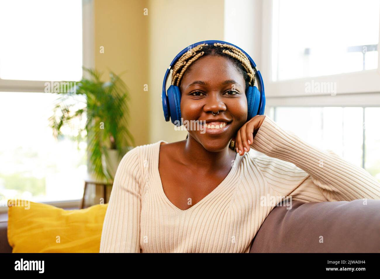 latin hispanic woman listen music while sitting on sofa in living room ...