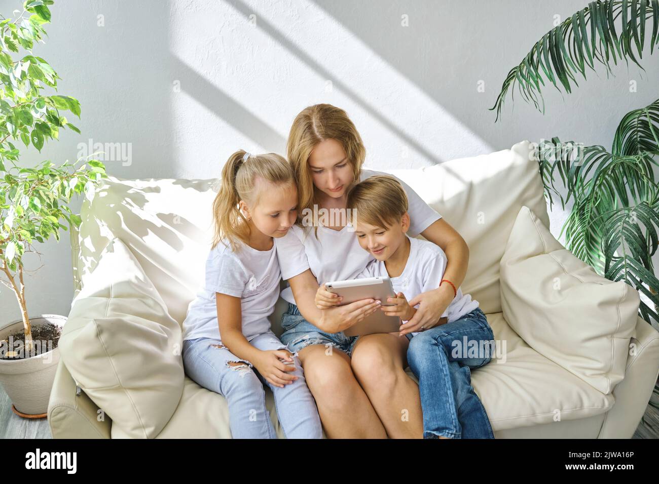 Young mother with kids daughter and boy using digital tablet computer ...