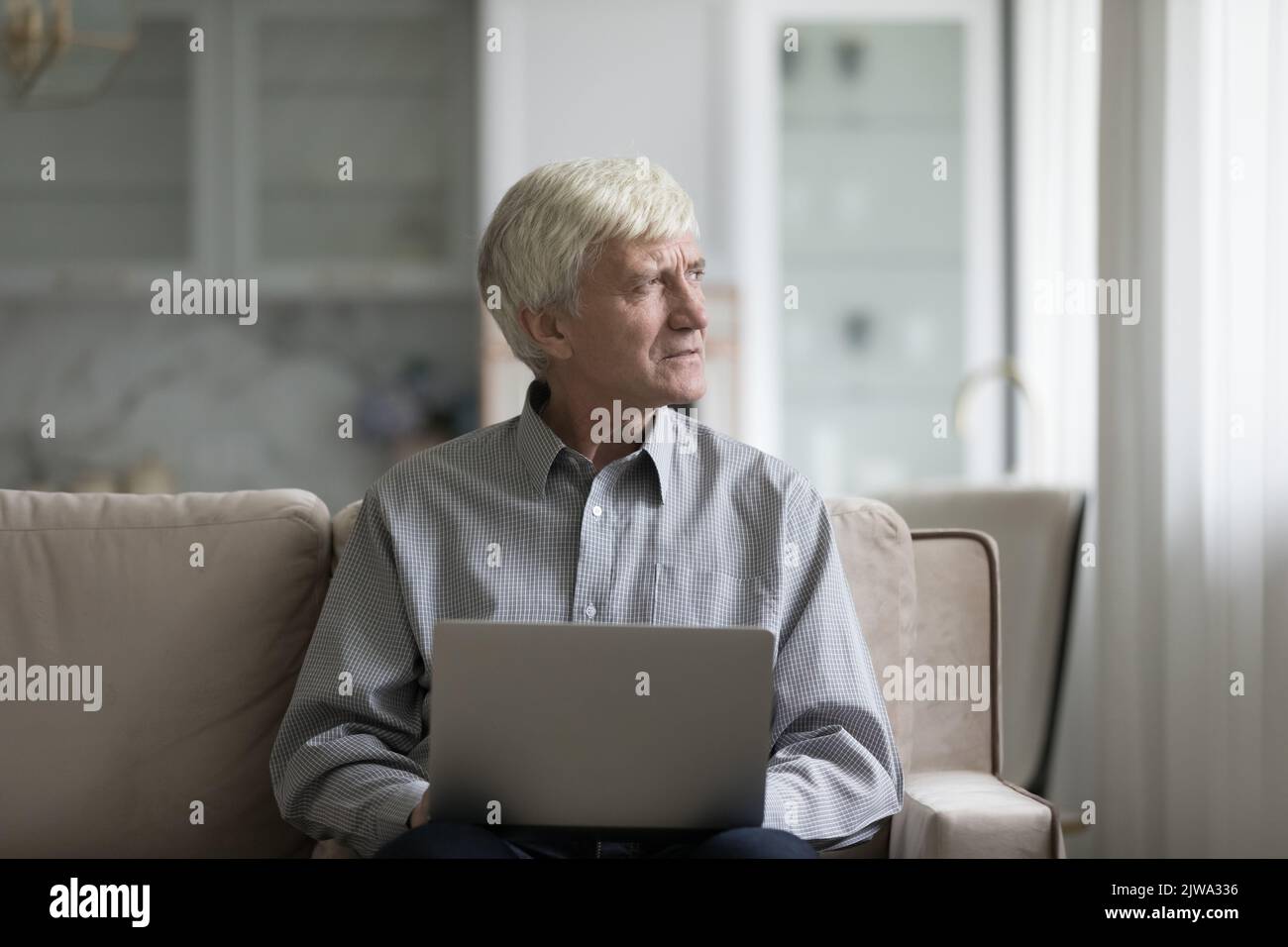 Thoughtful focused senior retired man holding laptop computer Stock ...
