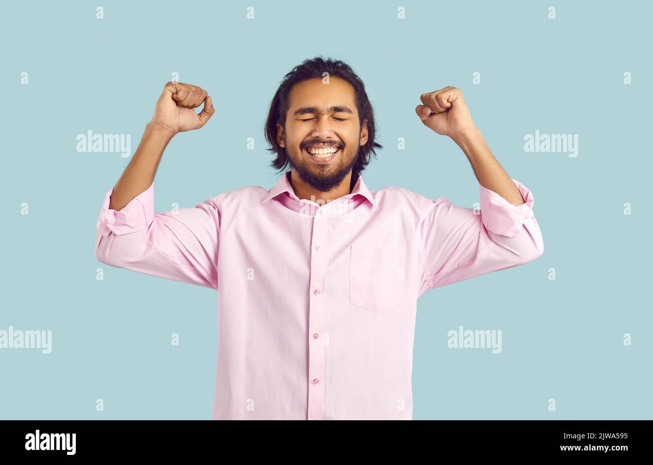 Absolutely happy excited Indian young man is sincerely happy on pastel ...