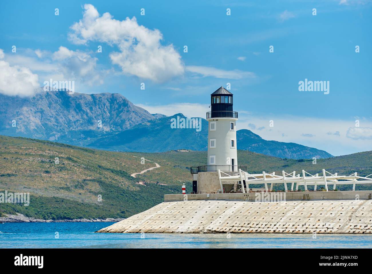Lighthouse by the sea against mountain in Lustica Bay, Montenegro Stock ...