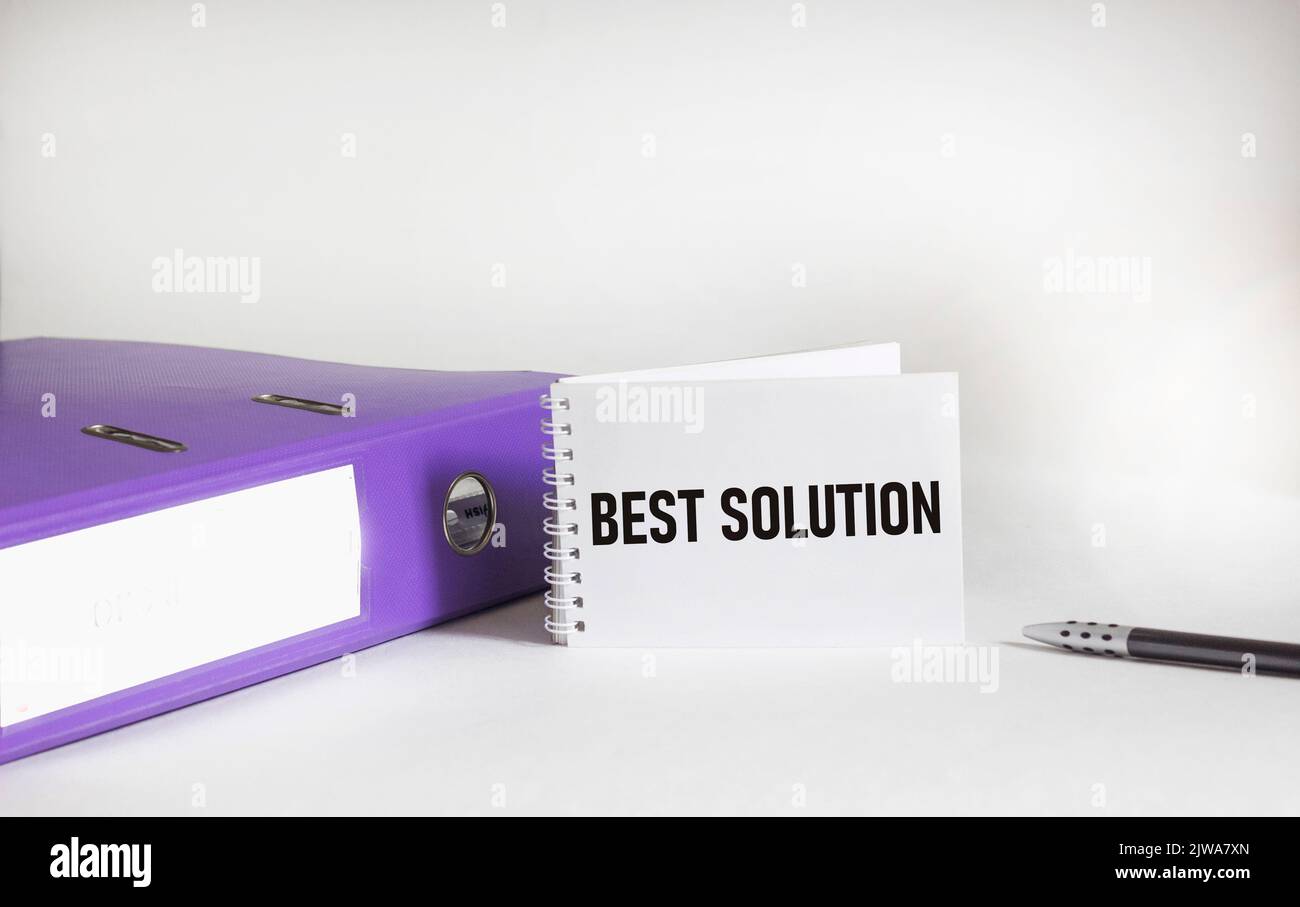 On a white notepad, the text BEST SOLUTION, next to a pen and a folder ...