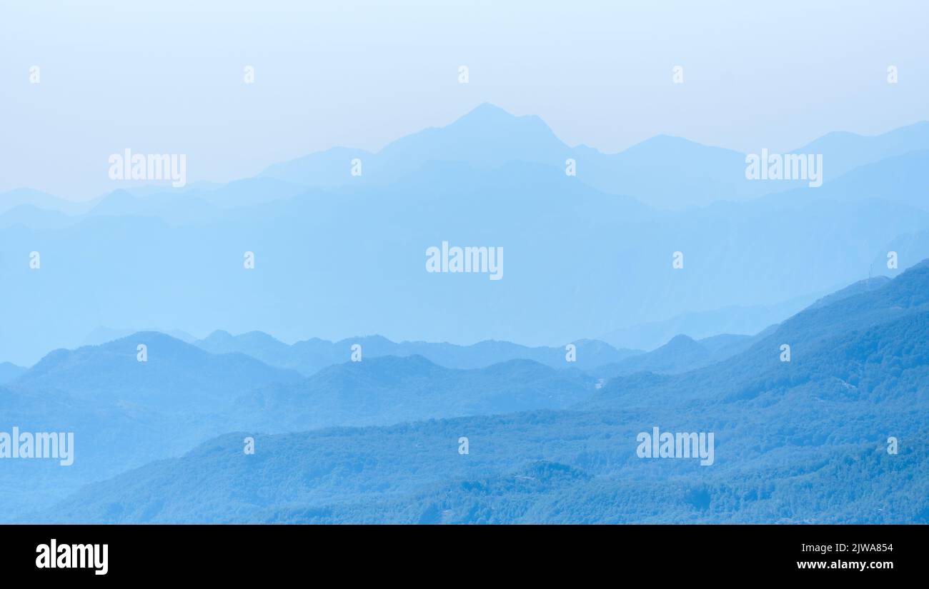 Mountain range silhouette in a blue haze Stock Photo - Alamy