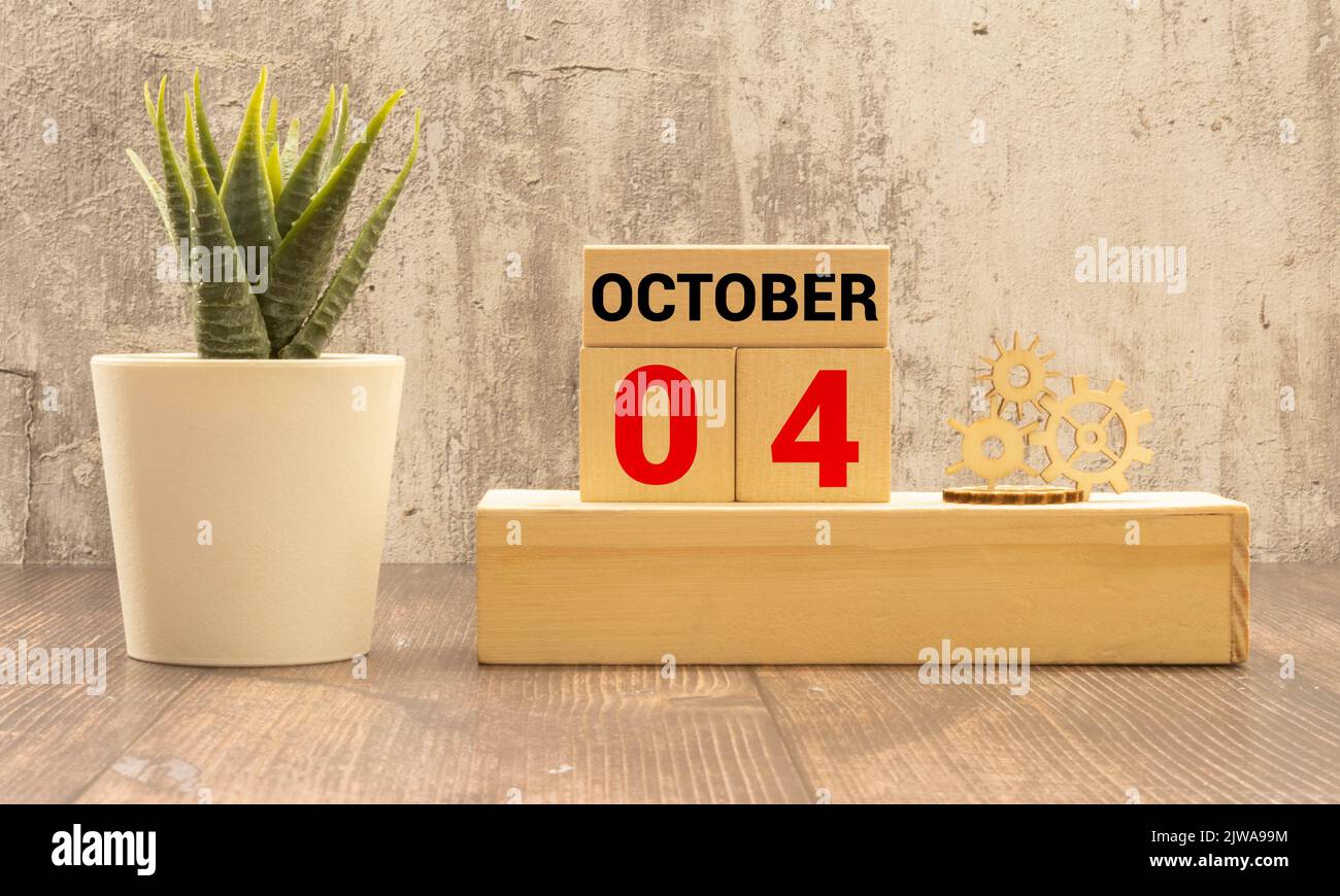 White block calendar present date 4 and month October on wood ba Stock ...