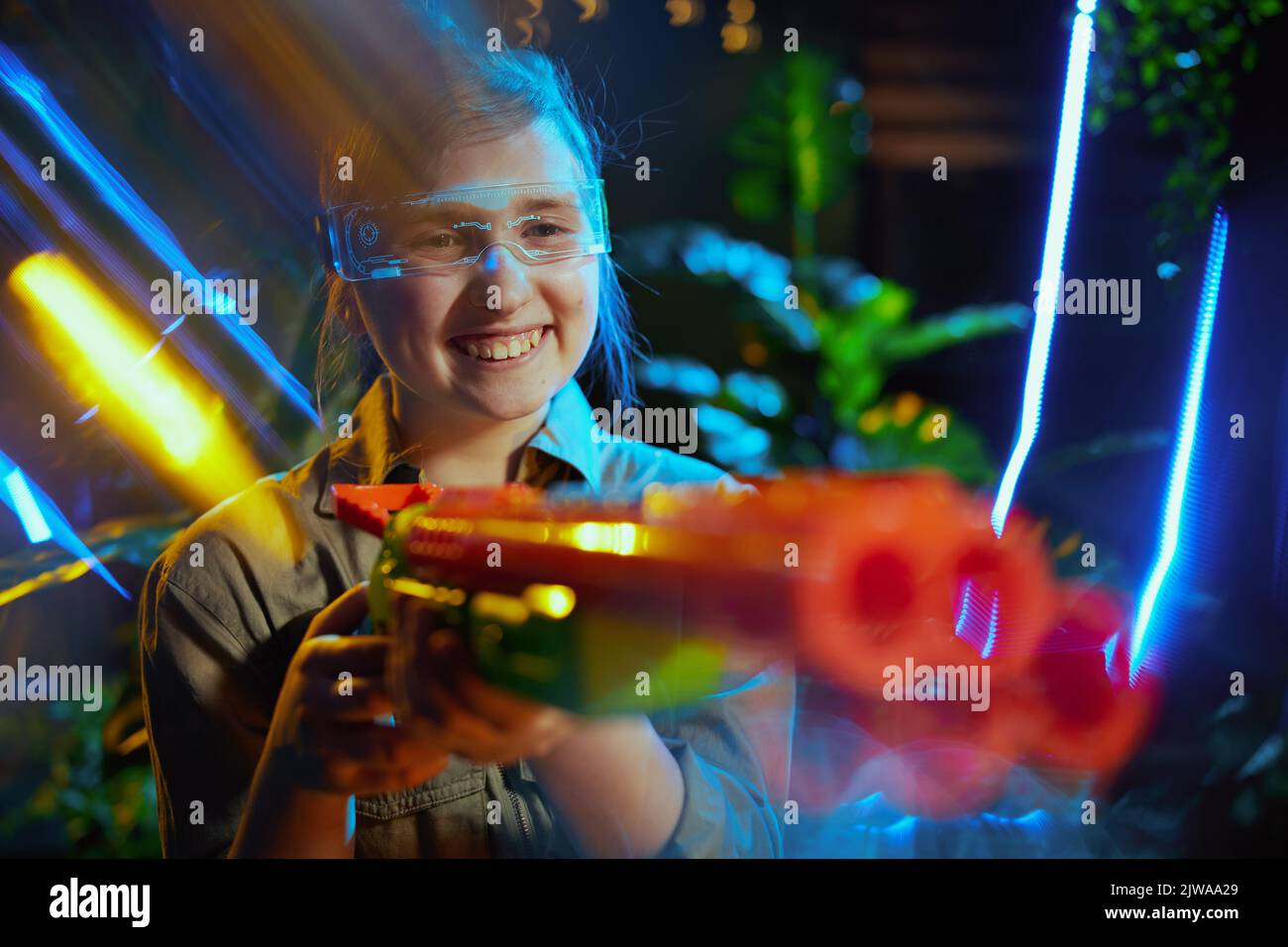 happy modern child with toy gun and futuristic glasses in virtual ...