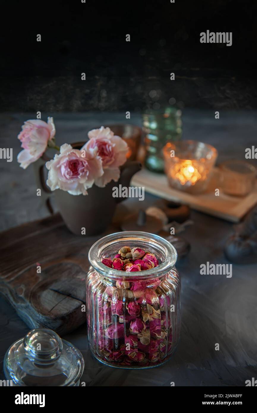 transparent fluted jar of pink tea stands on a wooden table. Tea time ...