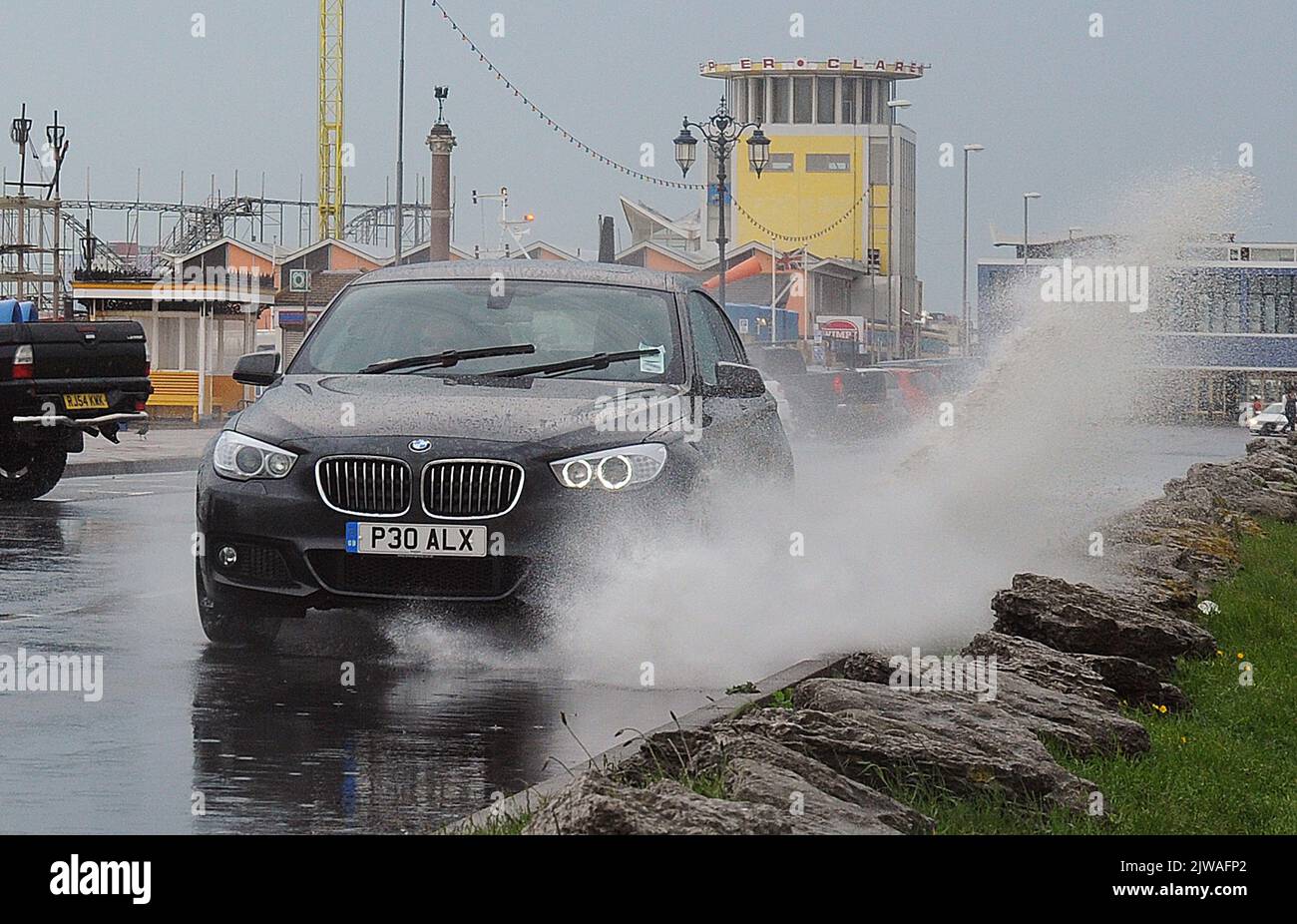 A CAR BATTLING THROUGH THE WATERLOGGED ROAD ON THE SEAFRONT AT SOUTHSEA ...
