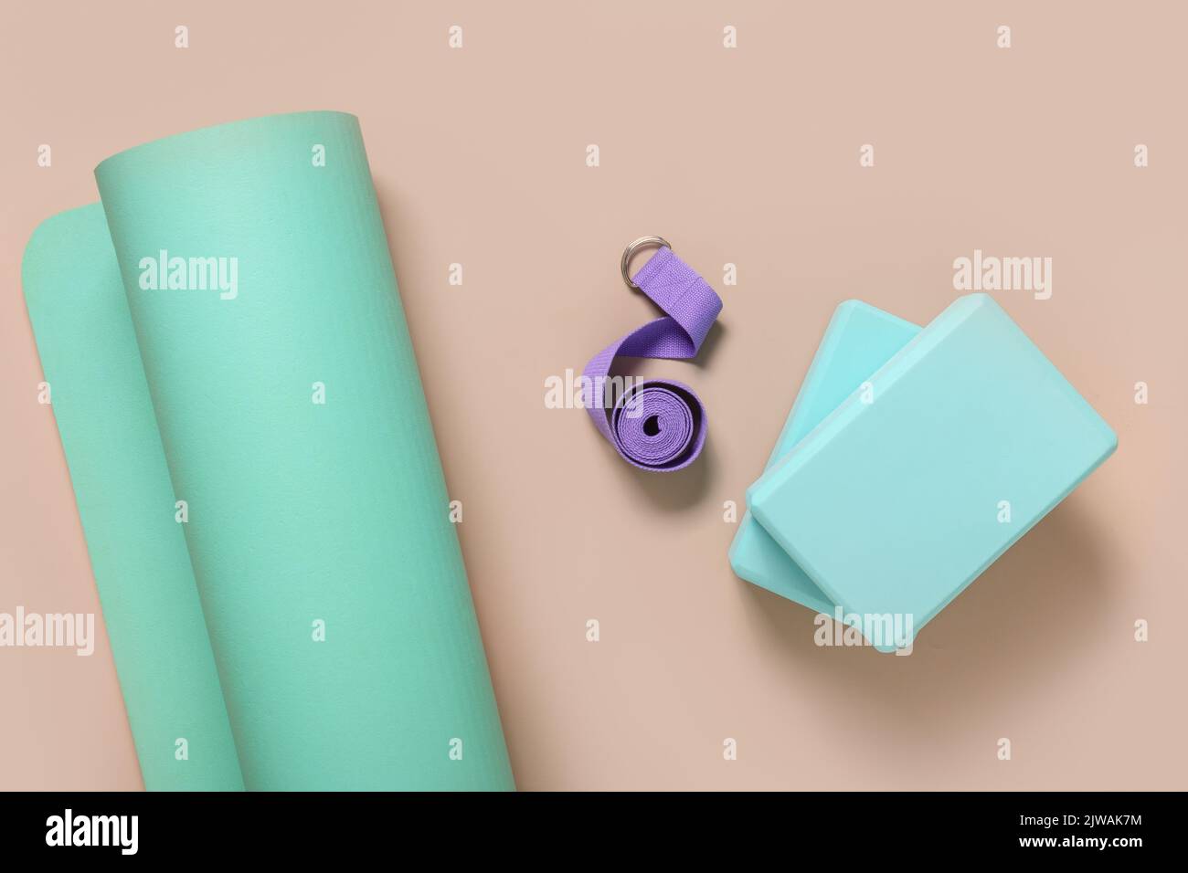 Green mat, two yoga blocks and belt on beige background. Top view. Yoga ...