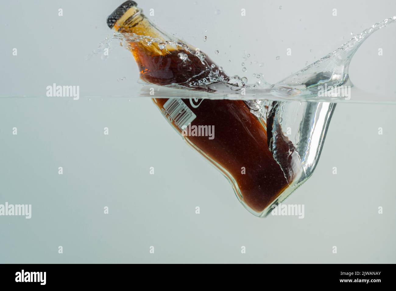 Close up view of drink Coca Cola bottle falling into water isolated on ...