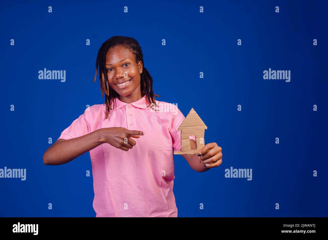 lady smiling as she points to a house Stock Photo - Alamy