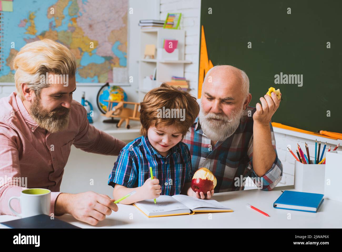 Fathers day. Happy smiling grandson boy with dad and granddad learning ...