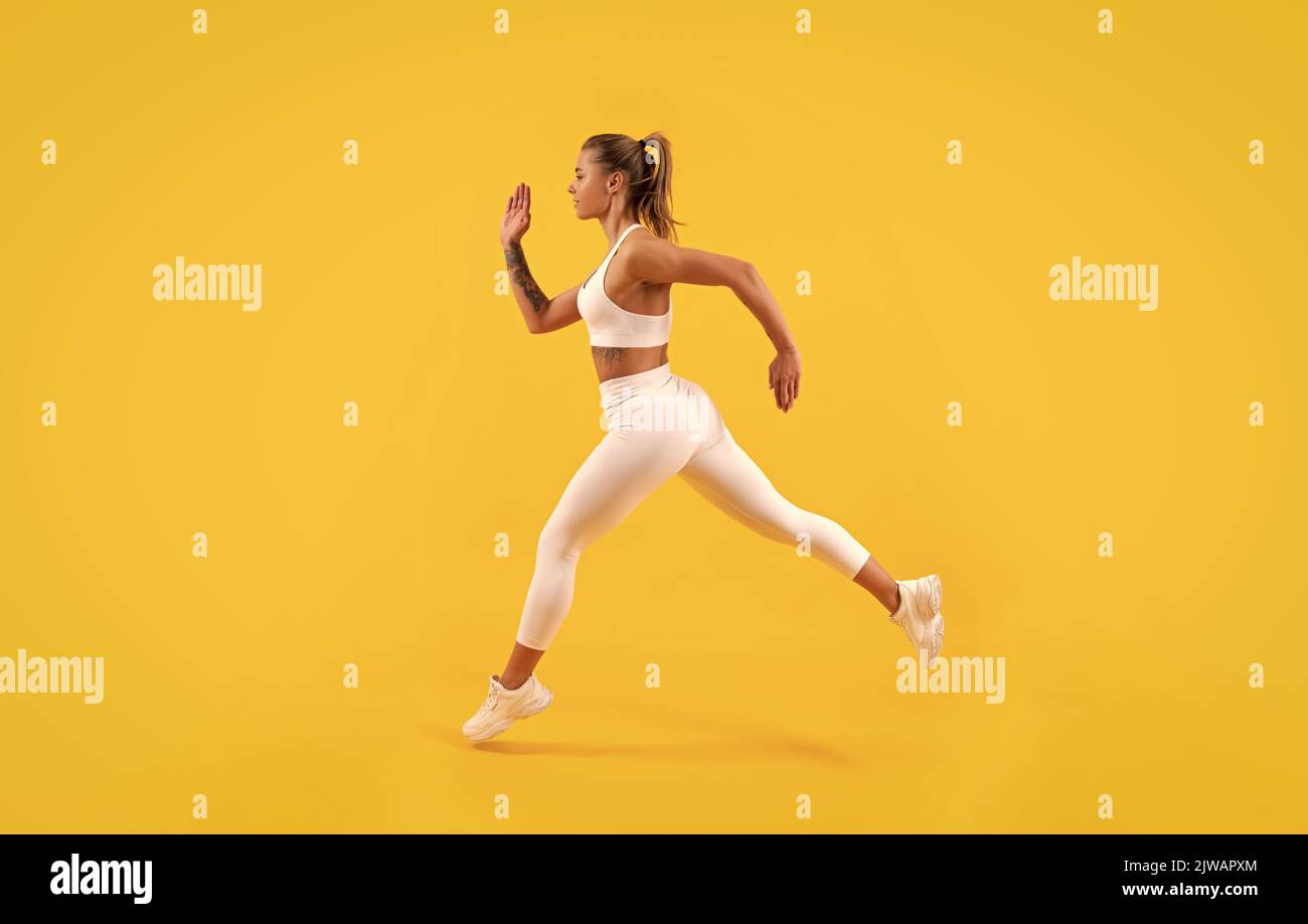 sport girl runner running on yellow background Stock Photo - Alamy