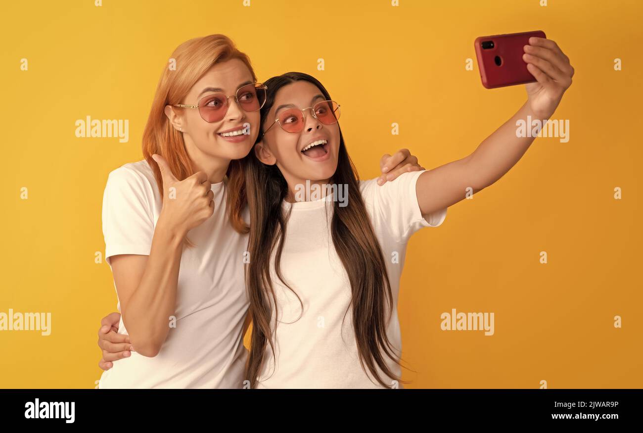 stylish mom and kid bloggers. happy woman and girl take selfie with ...