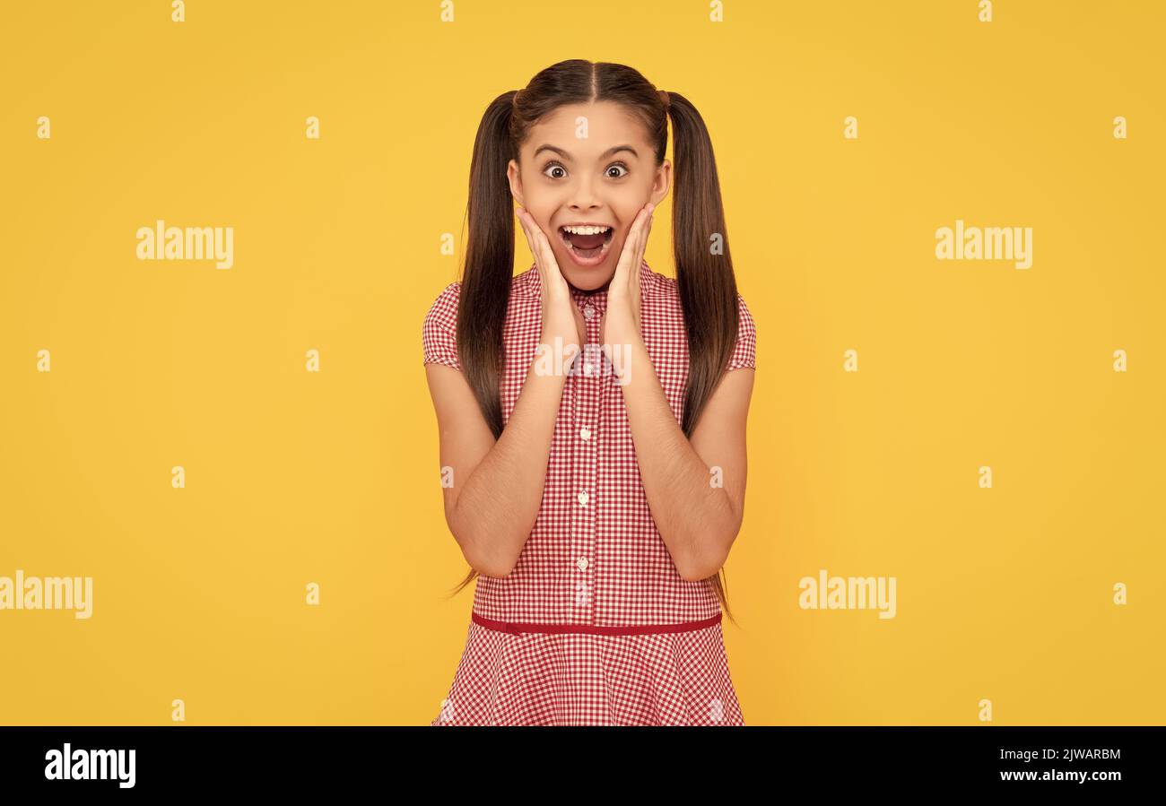 Shocked eye-popping tween girl show surprise yellow background, OMG ...