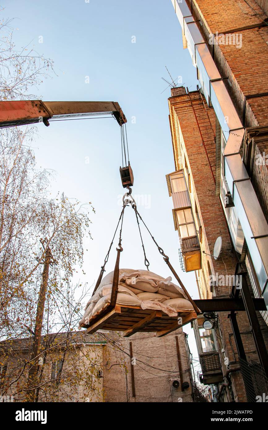 Loading sandbags for the renovation of an apartment in a five-story ...