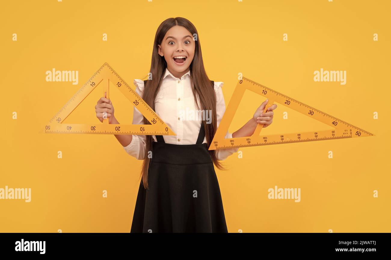 amazed teen girl in school uniform hold mathematics triangle for ...