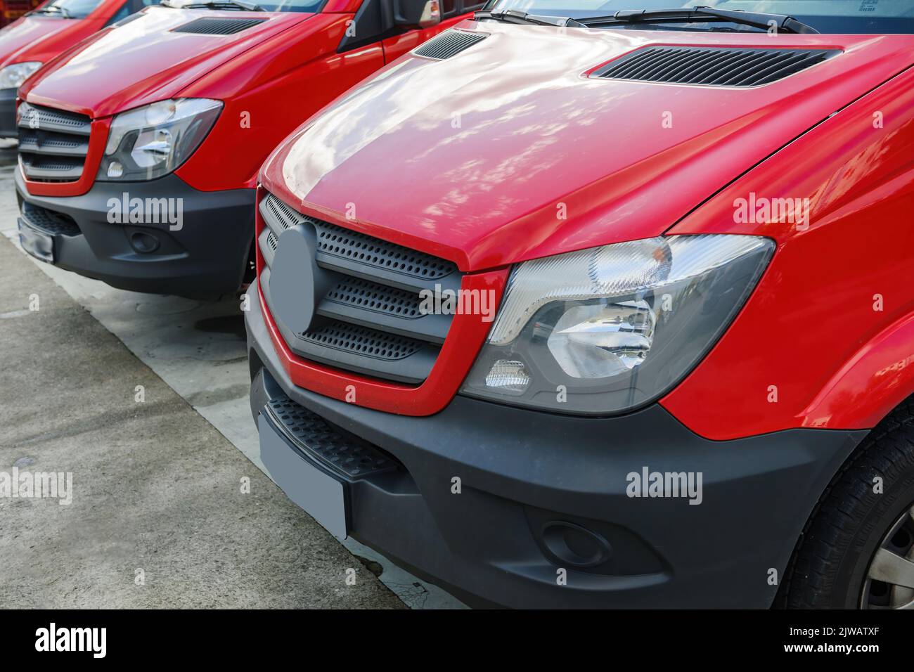 Close-up of row of red delivery vans parked in front of distribution ...