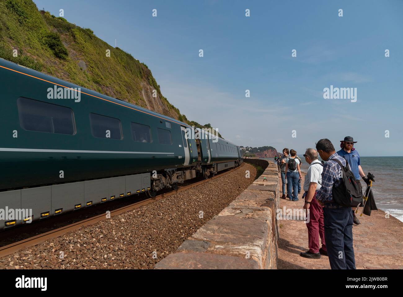Teignmouth, Devon, England, UK. 2022. Holidaymakers stop trackside to ...
