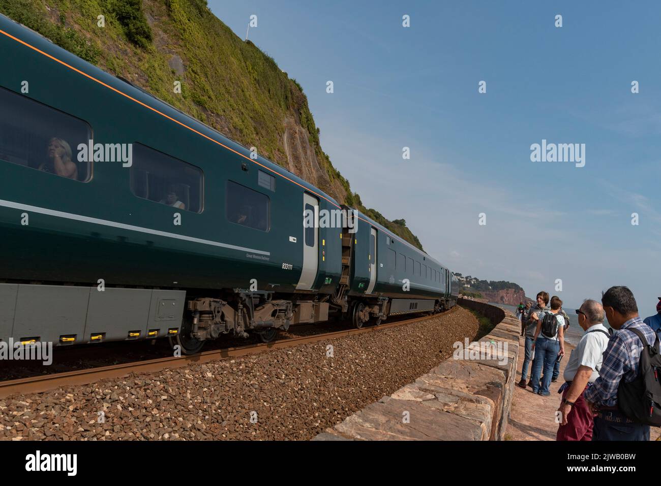 Teignmouth, Devon, England, UK. 2022. Holidaymakers stop trackside to ...