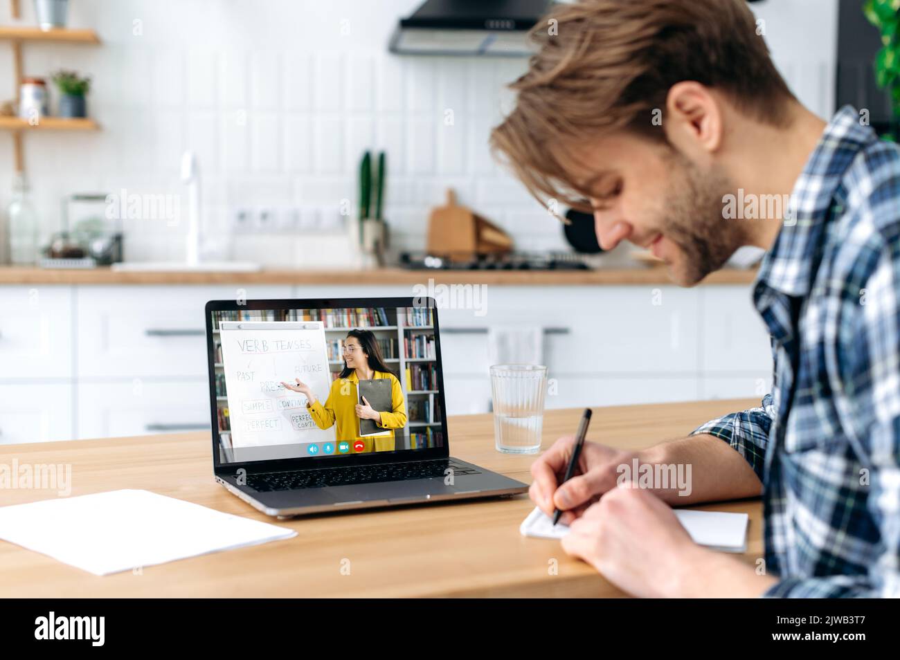 Online learning. Side view of a smart positive caucasian student guy ...