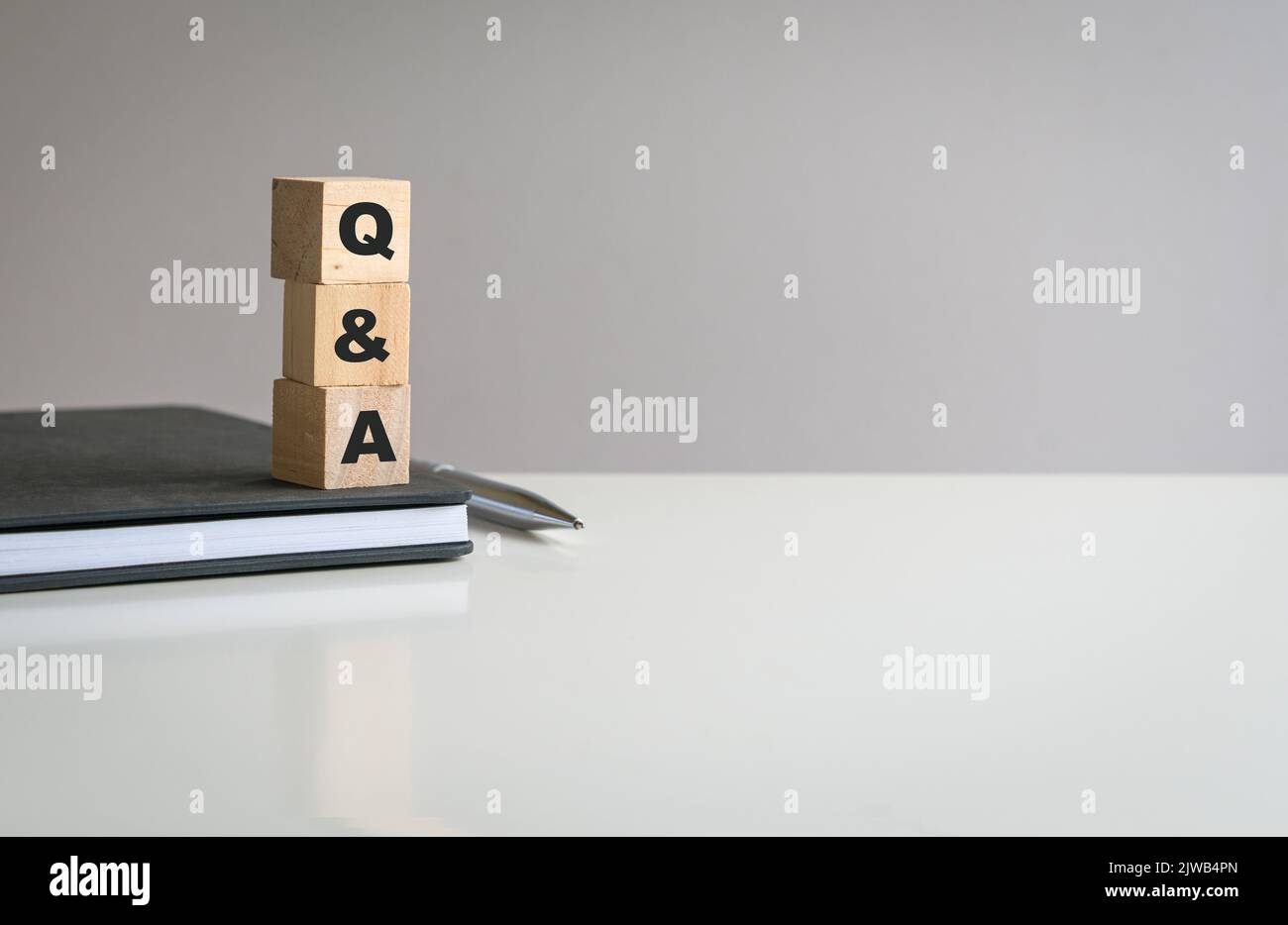 Alphabet Q & A on wood block cube, on top of notepad. Questions and answers concept Stock Photo ...