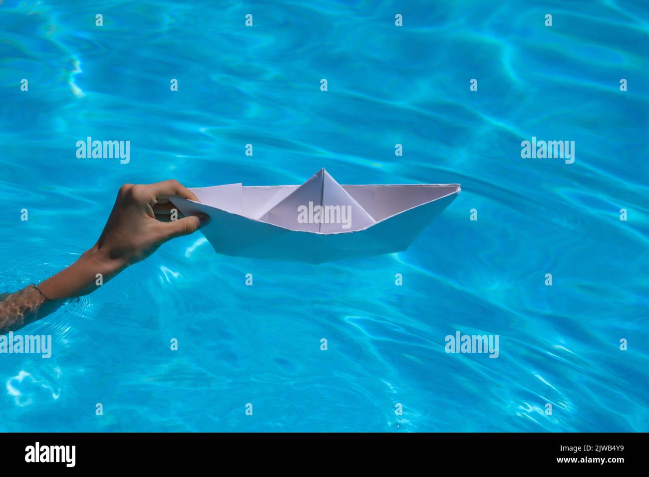 Paper ship in hand ready to sail. Hand holding paper boat on the sea ...