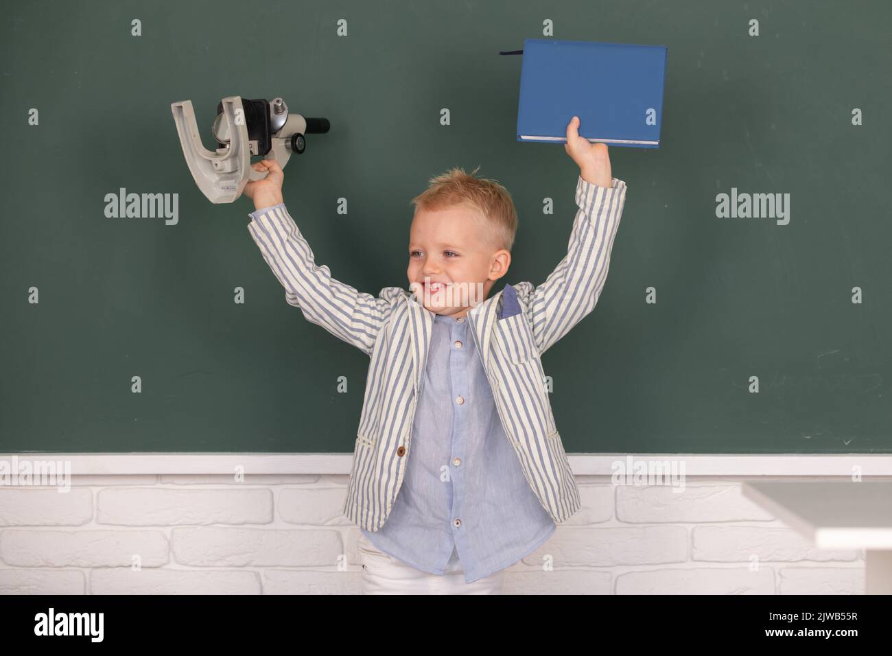 Funny face of little student of primary school study in classroom at ...