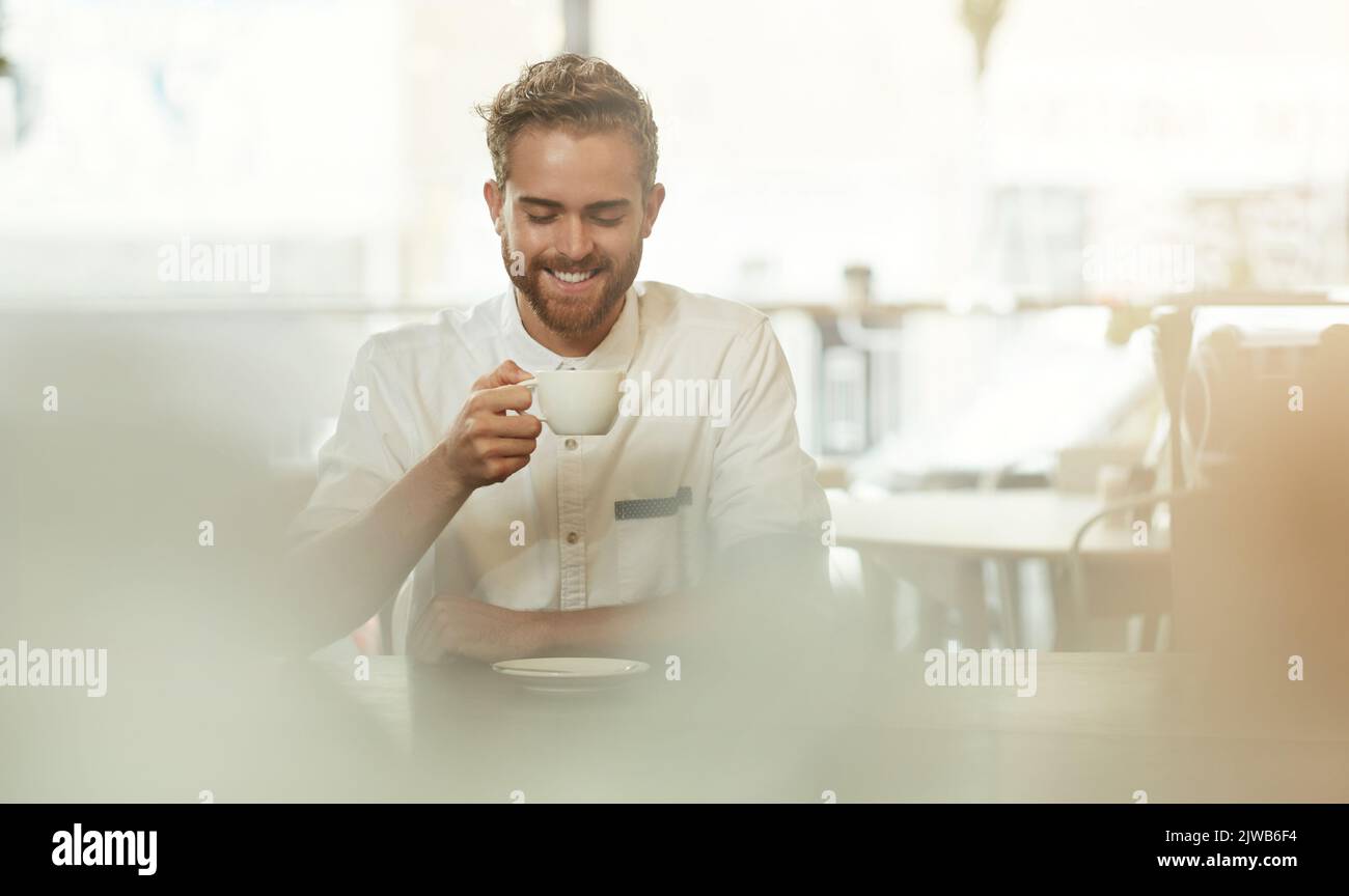 Sometimes a cup of coffee is all you need. a young man sitting at a ...