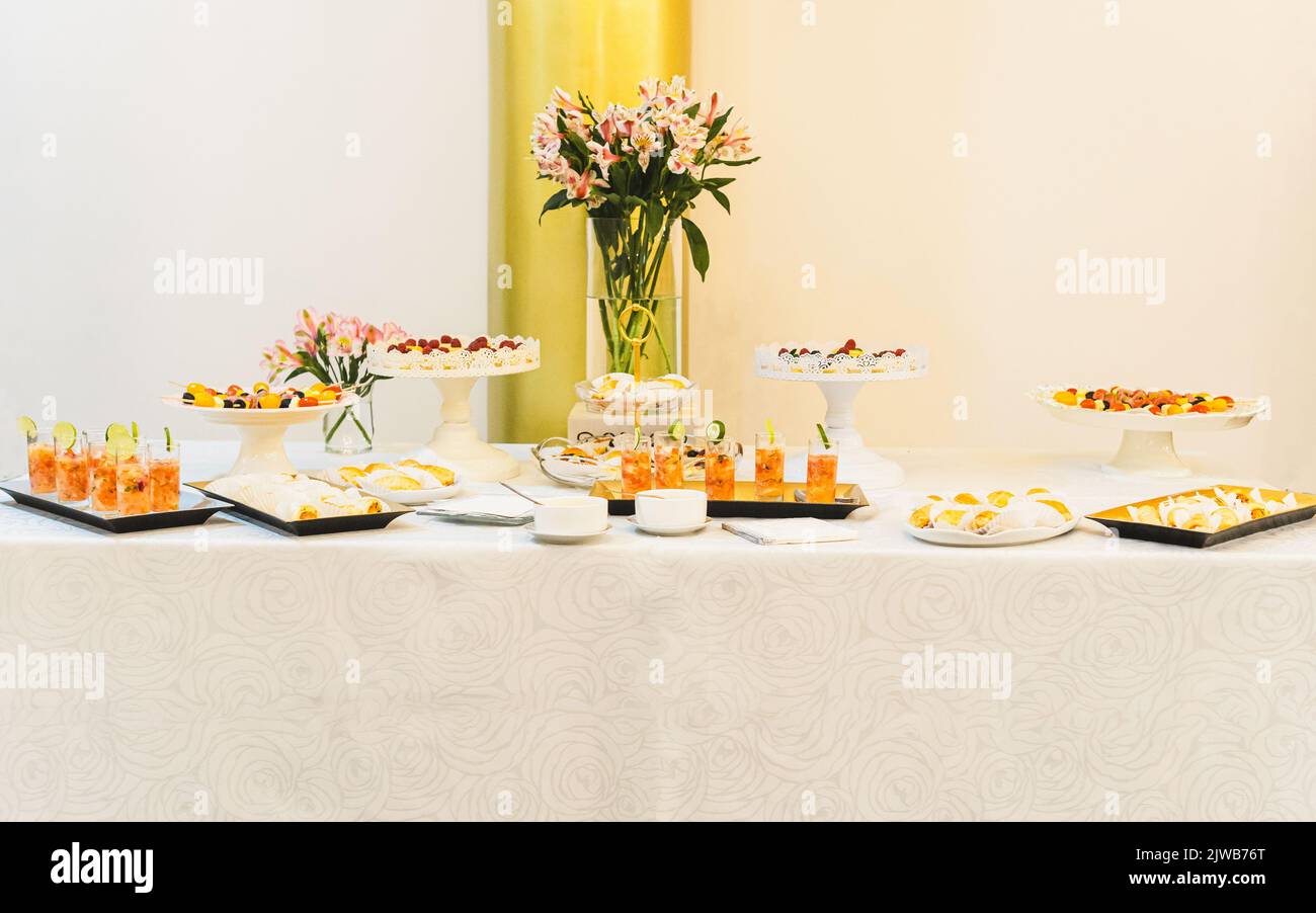 Buffet table with tablecloth with different salty and sweet snacks ...