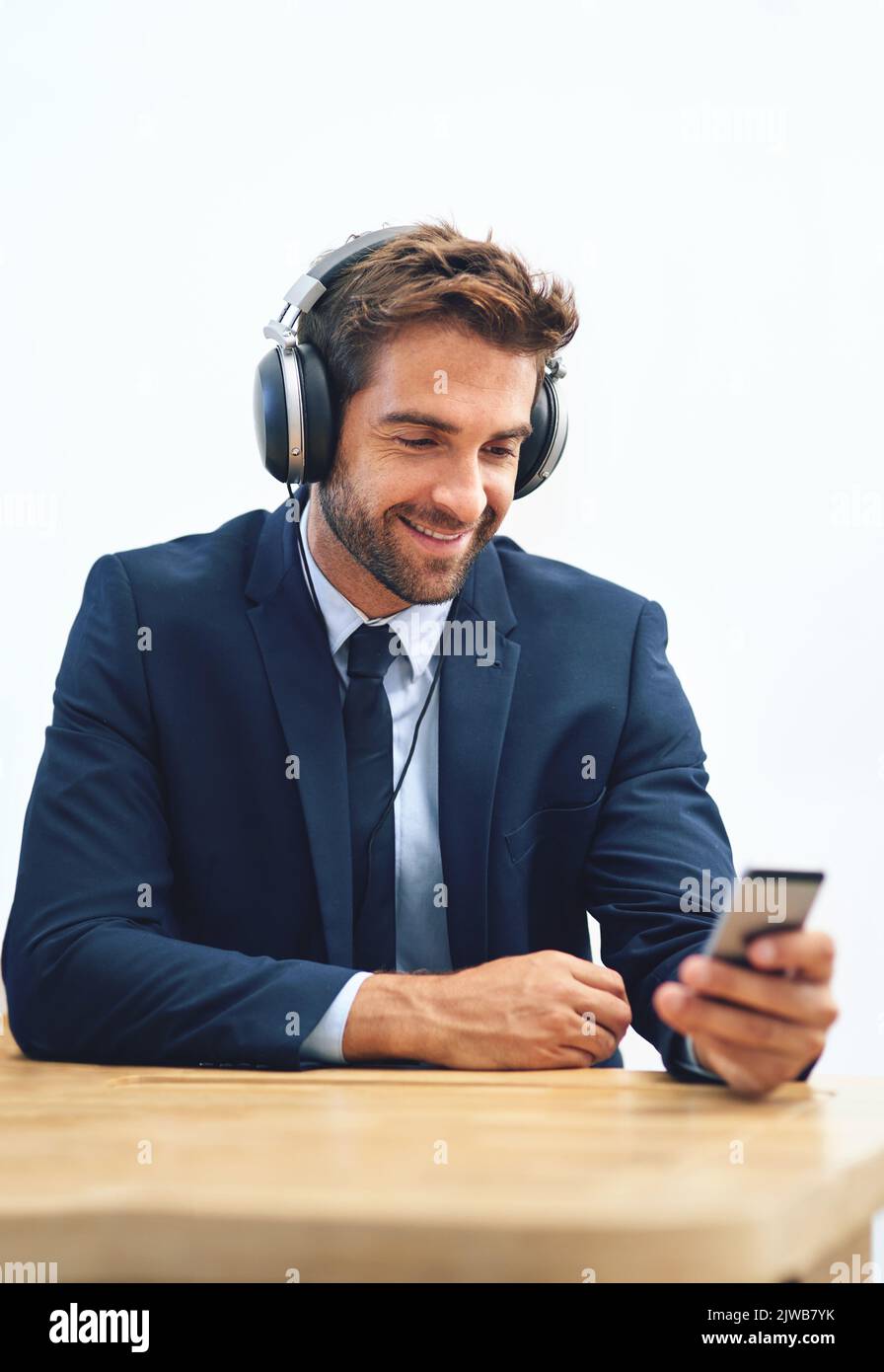 Work hard, play hard. a handsome young businessman listening to music ...