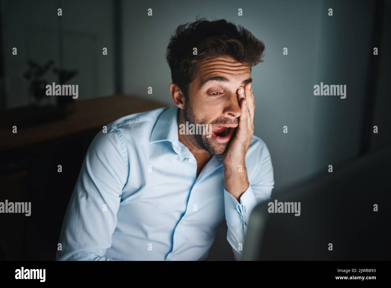 Must... stay... awake...a young businessman yawning while working late ...