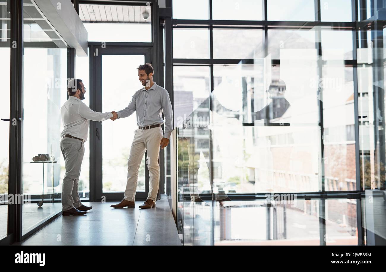 Forming partnerships to help better business. two businessmen shaking ...