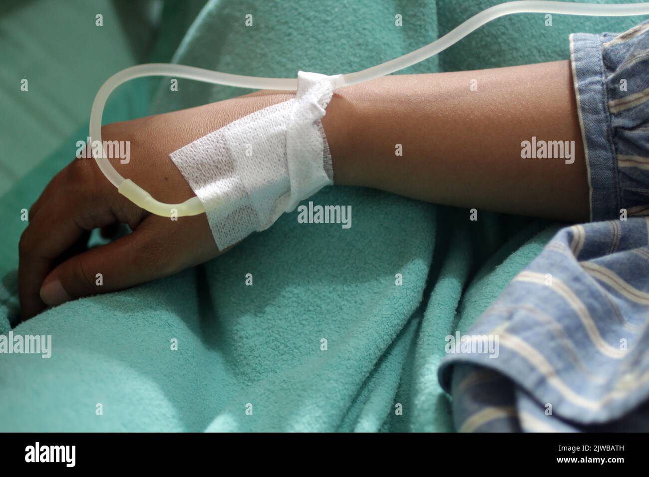 Female patient with iv on hand in the hospital. An Asian female patient ...