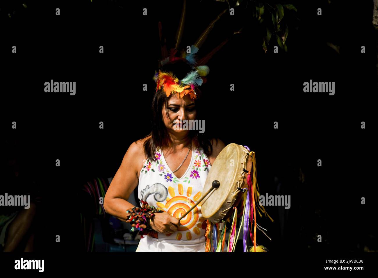 An indigenous woman plays a traditional instrument during the ...