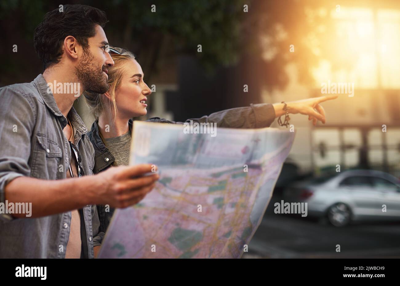 I know exactly where were going. a young couple using a map while ...