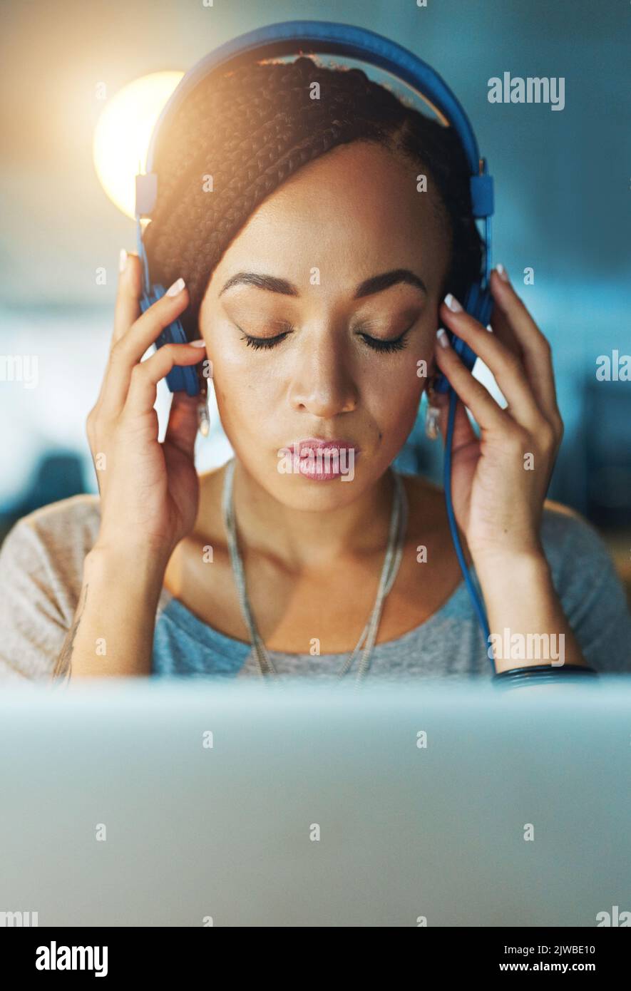 Music gets her in the zone. a young woman listening to music while ...