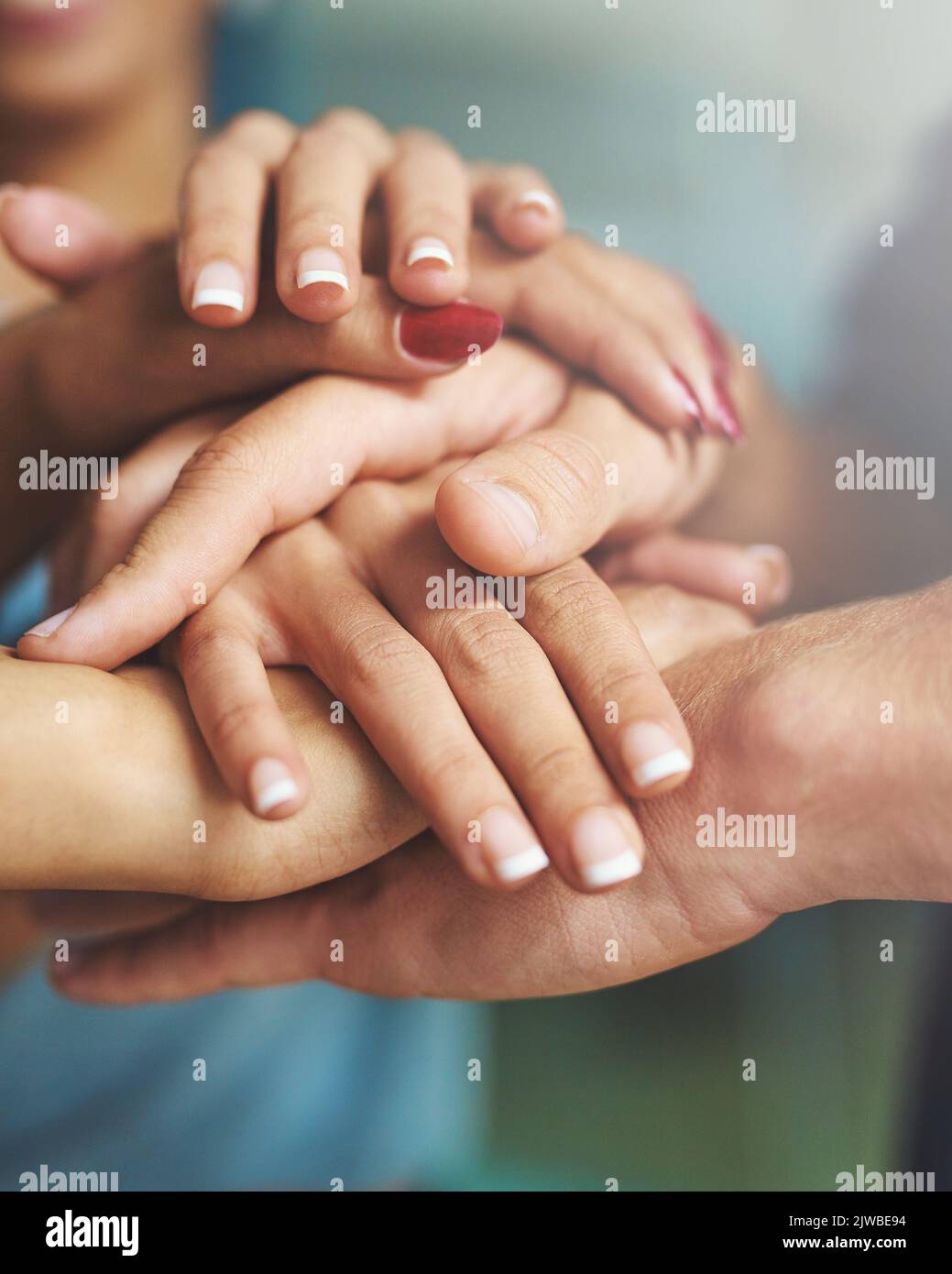 Keeping the team together. a group of colleagues joining their hands ...