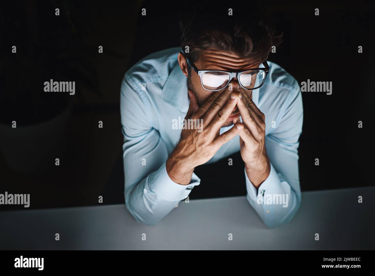 Tired, overworked and under extreme pressure. a young businessman ...