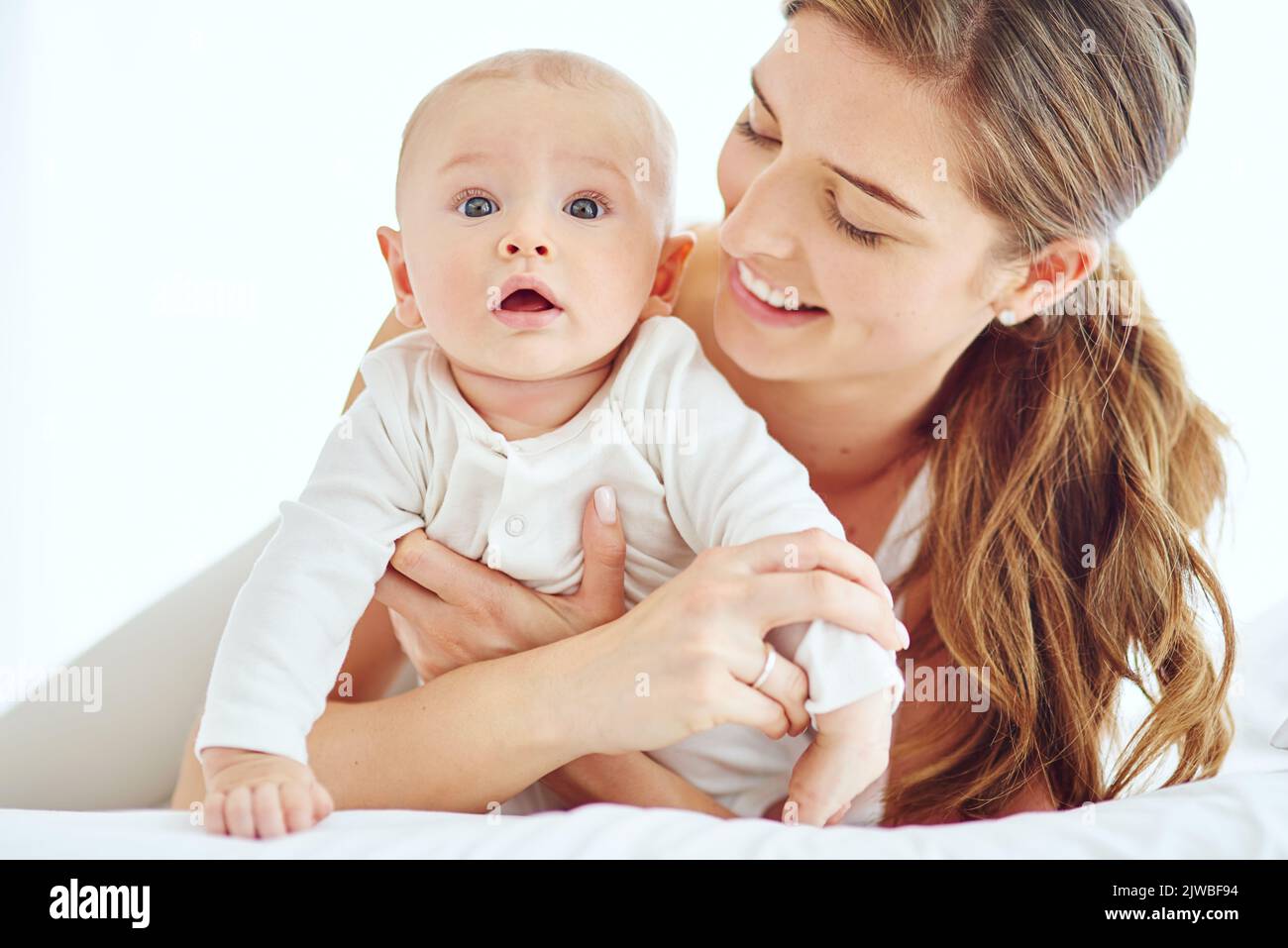 Mom is the best cuddle buddy. a young mother bonding with her adorable ...